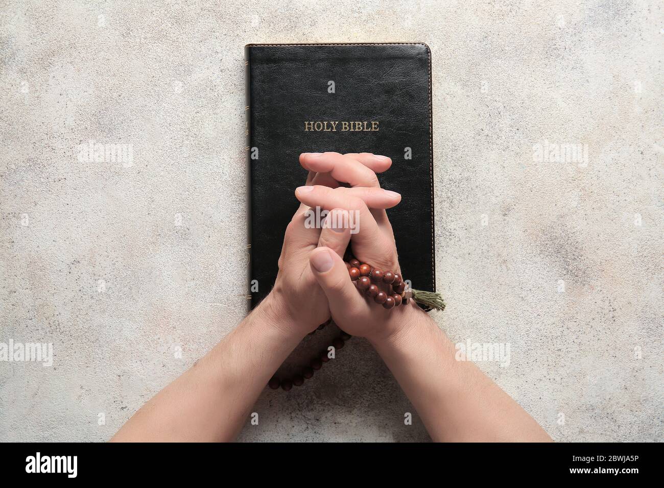 Religious man praying at table, top view Stock Photo - Alamy