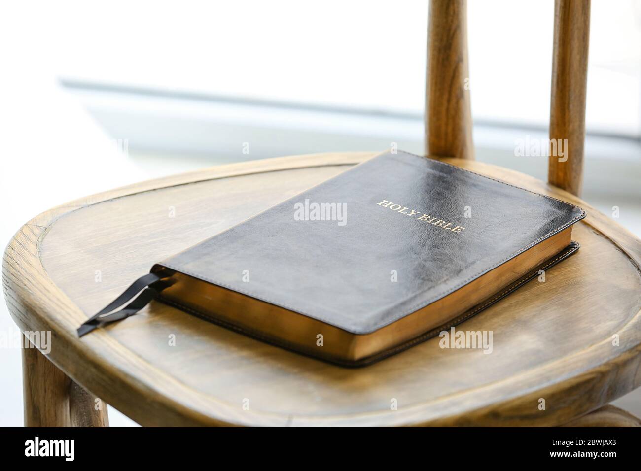 Holy Bible on chair in room Stock Photo - Alamy