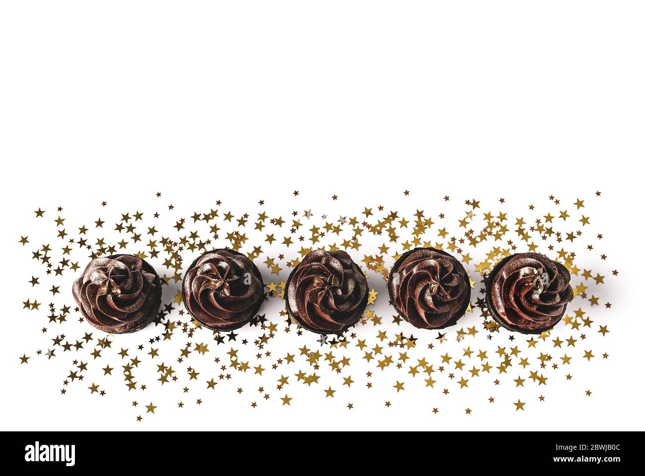 Chocolate cupcakes with chocolate icing and sprinkled gold sparkles on ...