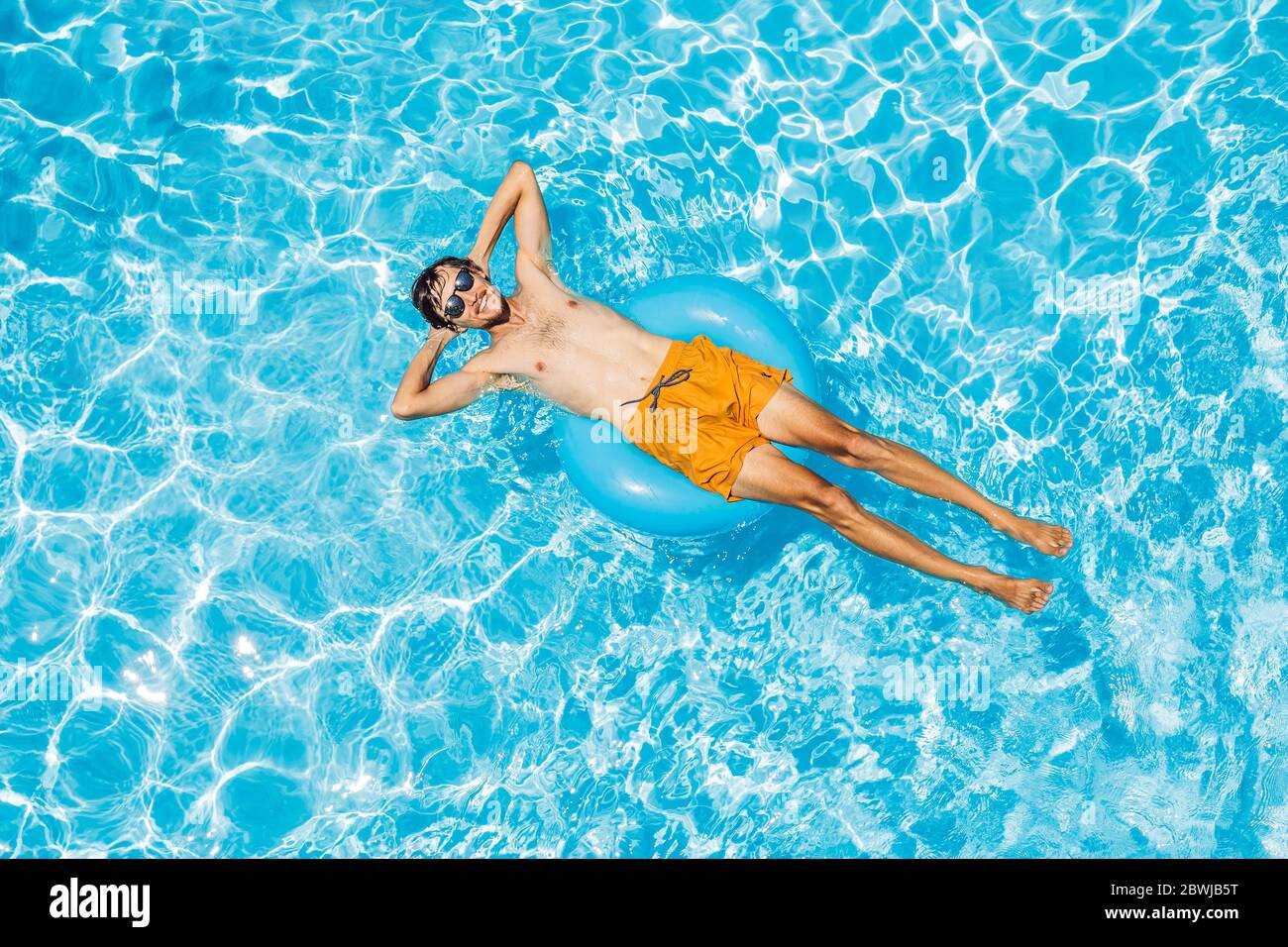 Young man swims in the pool, summer vacation concept Stock Photo - Alamy