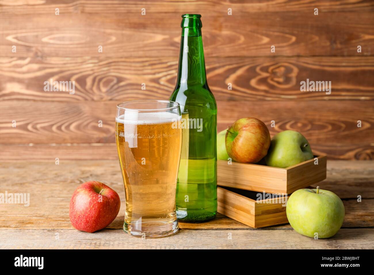 Bottle and glass of apple cider on table Stock Photo - Alamy