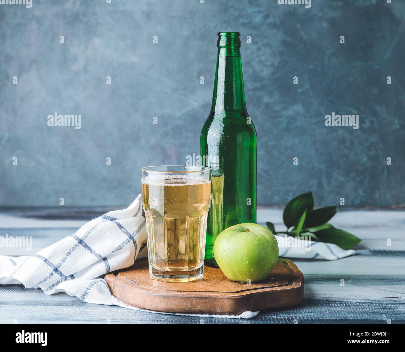 Bottle and glass of apple cider on table Stock Photo - Alamy