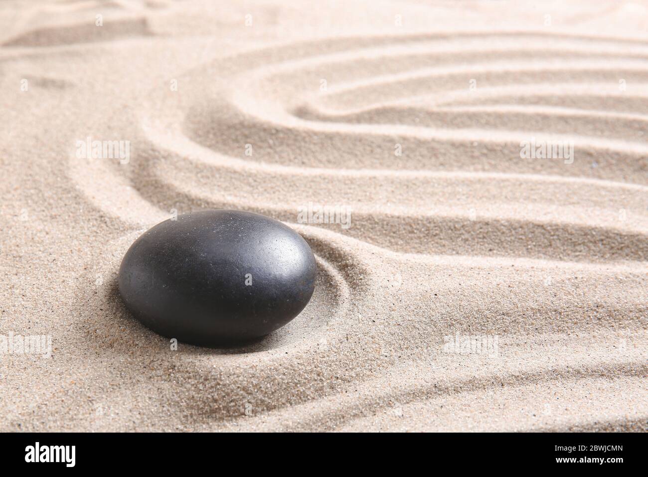 Stone on sand with lines. Zen concept Stock Photo - Alamy