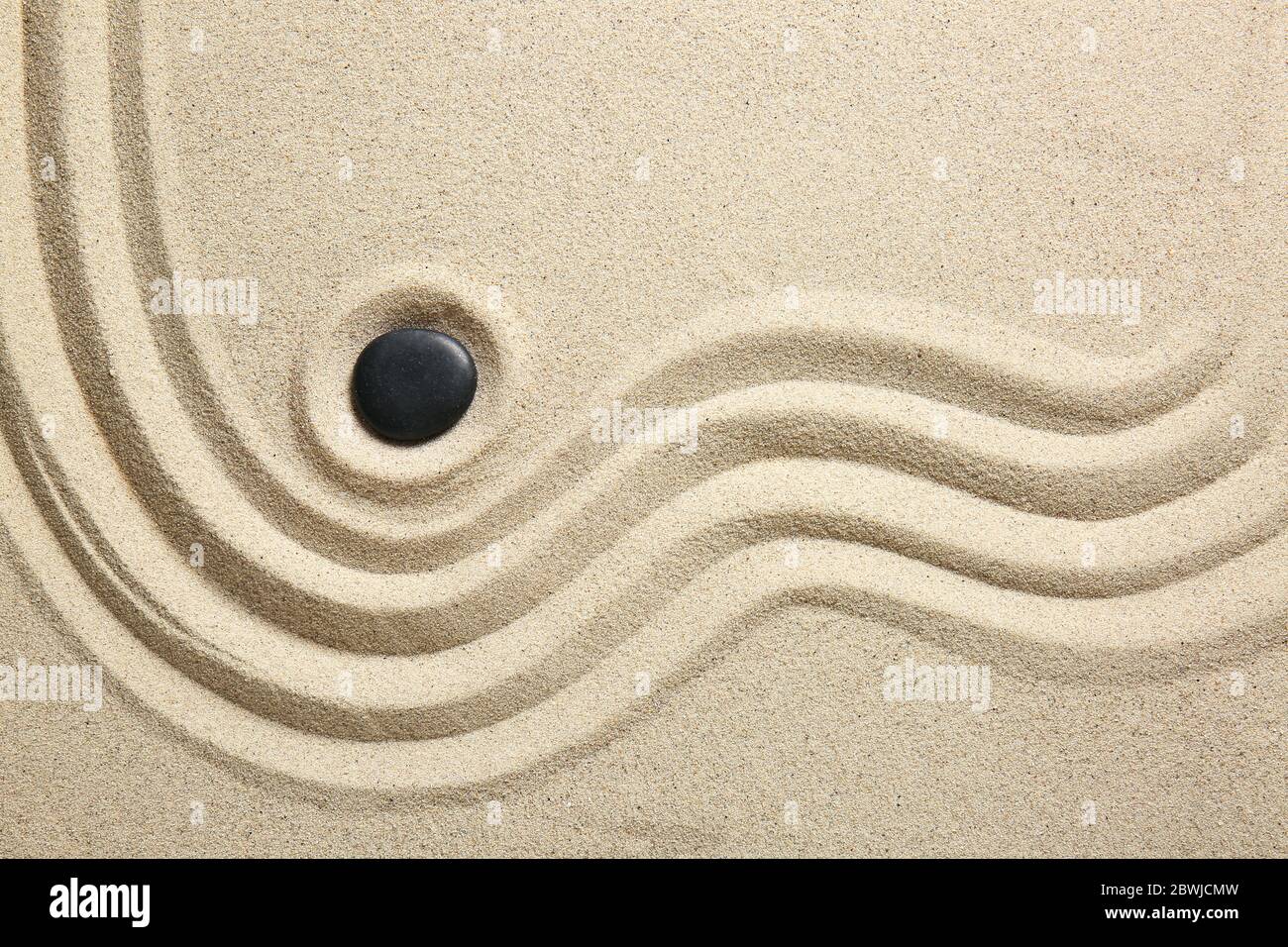 Stone on sand with lines. Zen concept Stock Photo - Alamy