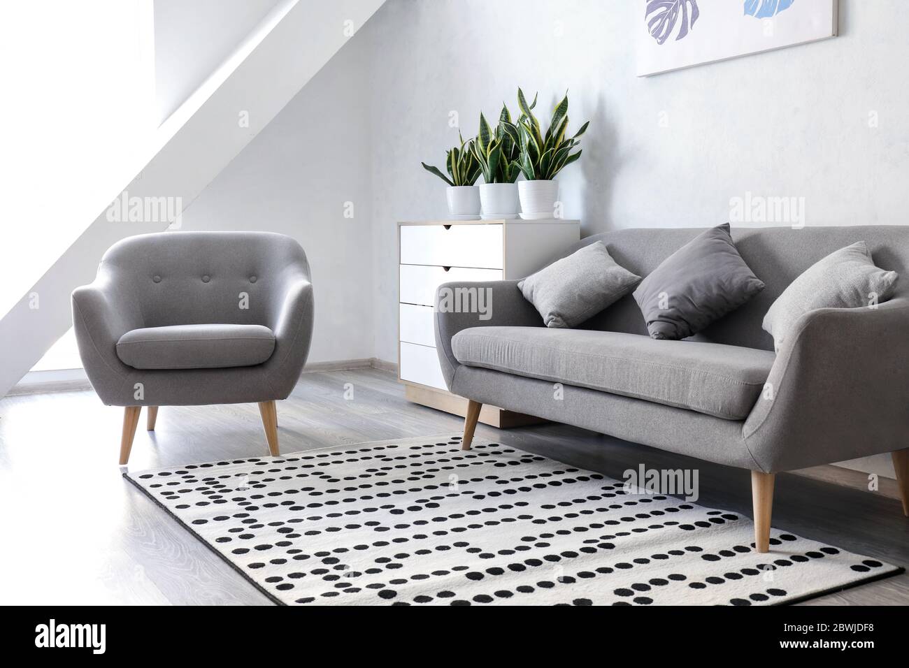 Interior of modern room with comfortable armchair and sofa Stock Photo ...