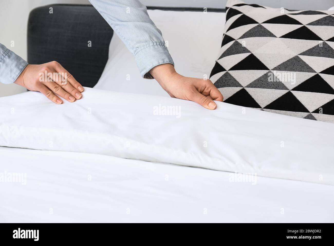 Woman making bed at home Stock Photo - Alamy