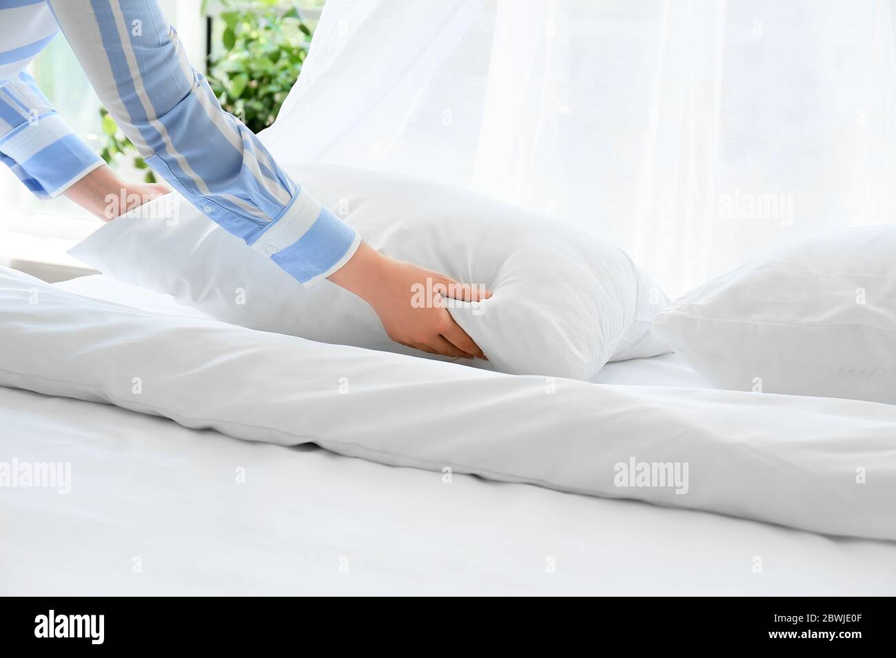 Woman making bed at home Stock Photo - Alamy