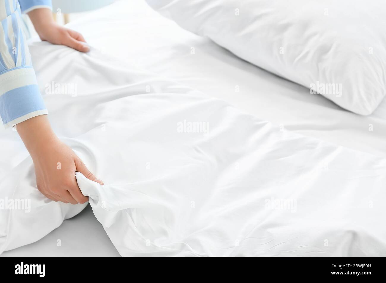 Woman making bed at home Stock Photo - Alamy