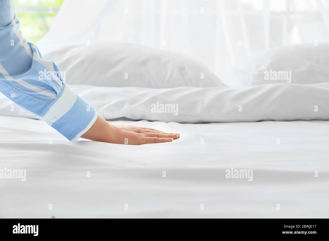 Woman making bed at home Stock Photo - Alamy