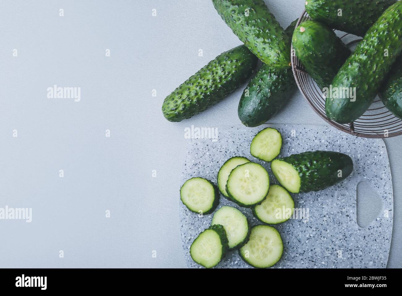 Composition with fresh green cucumbers on light background Stock Photo ...