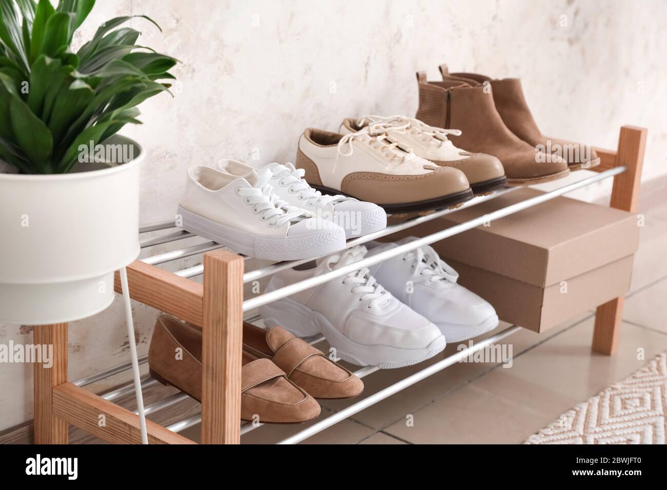Stand with stylish shoes in interior of modern hall Stock Photo - Alamy