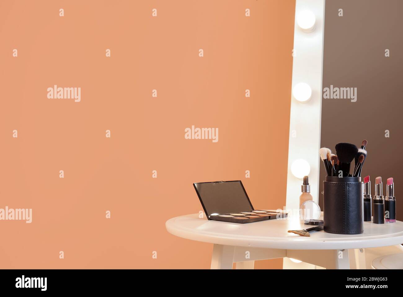 Table with makeup cosmetics in dressing room Stock Photo - Alamy