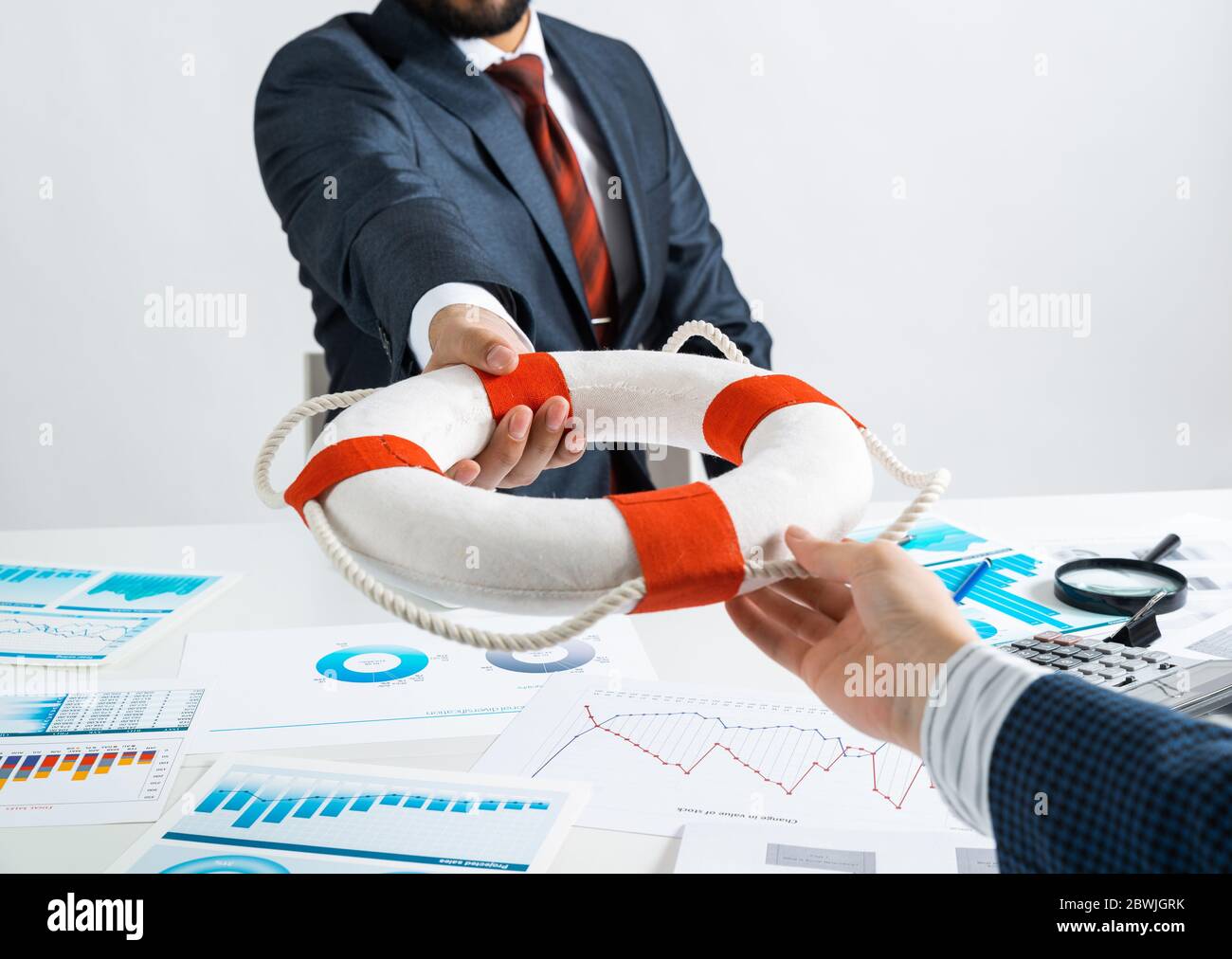 Business persons holding small lifebuoy together Stock Photo - Alamy