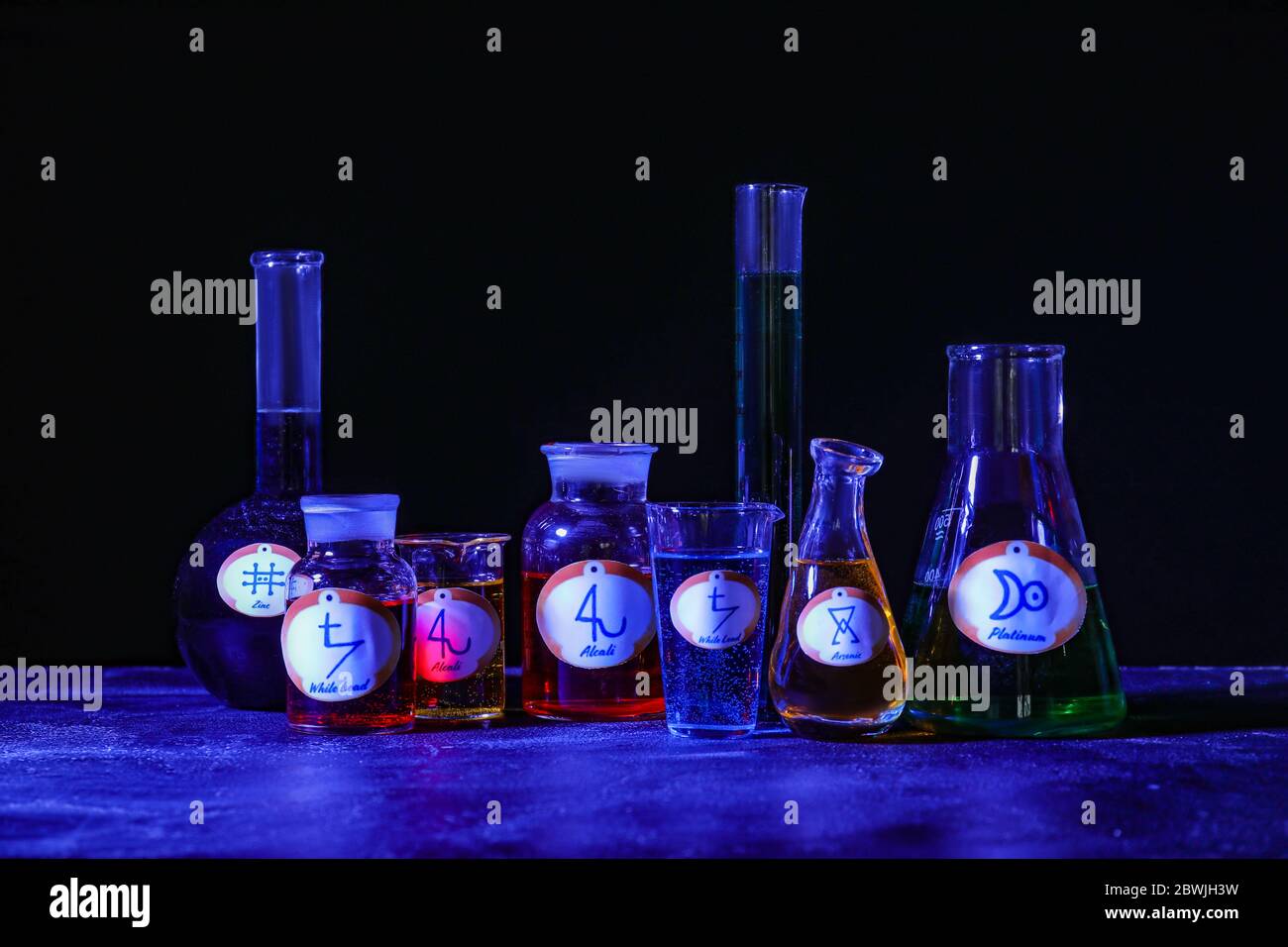Potions with alchemical symbols on table Stock Photo - Alamy