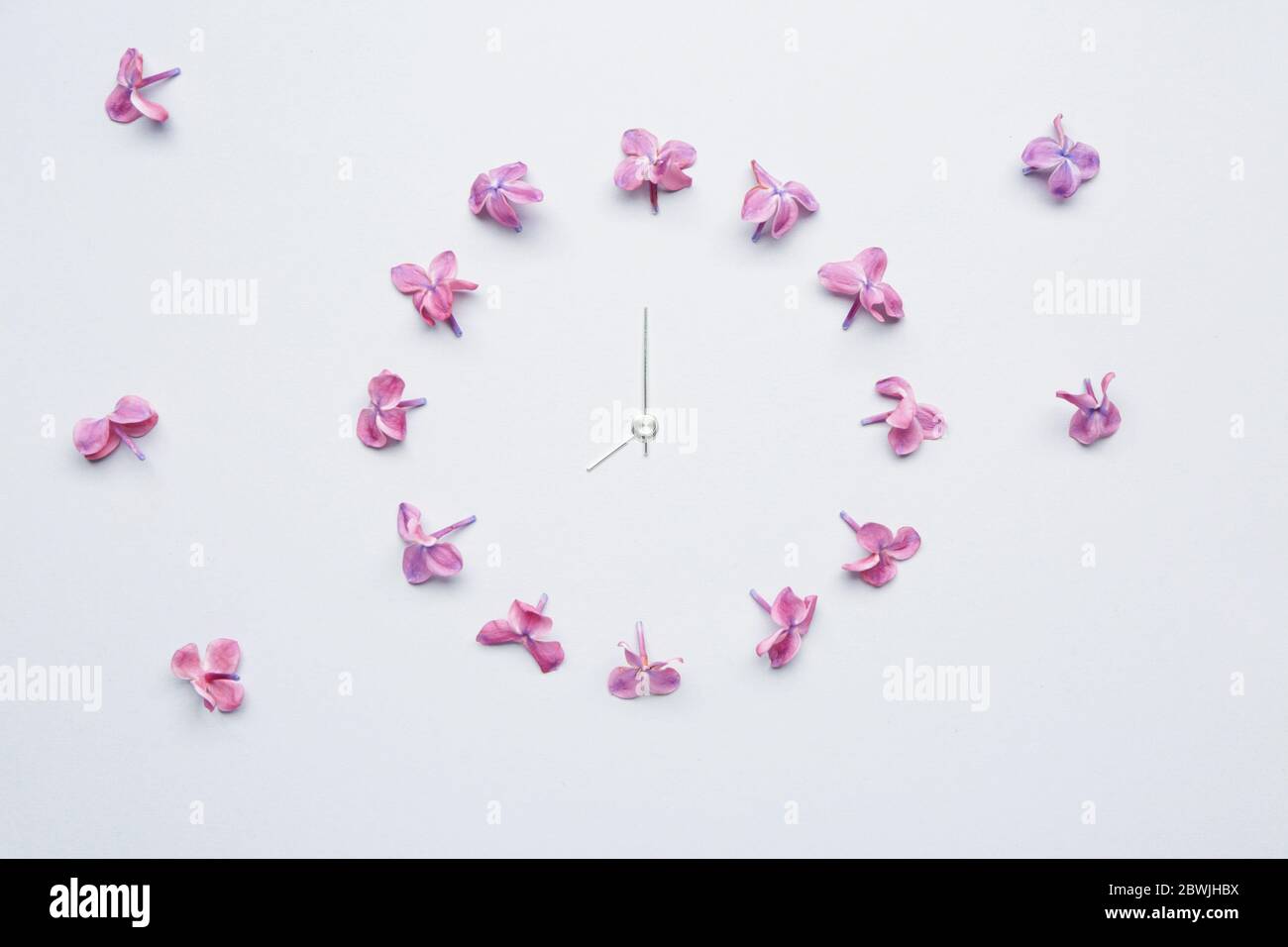 Clock made of flowers on light background. Spring time Stock Photo - Alamy