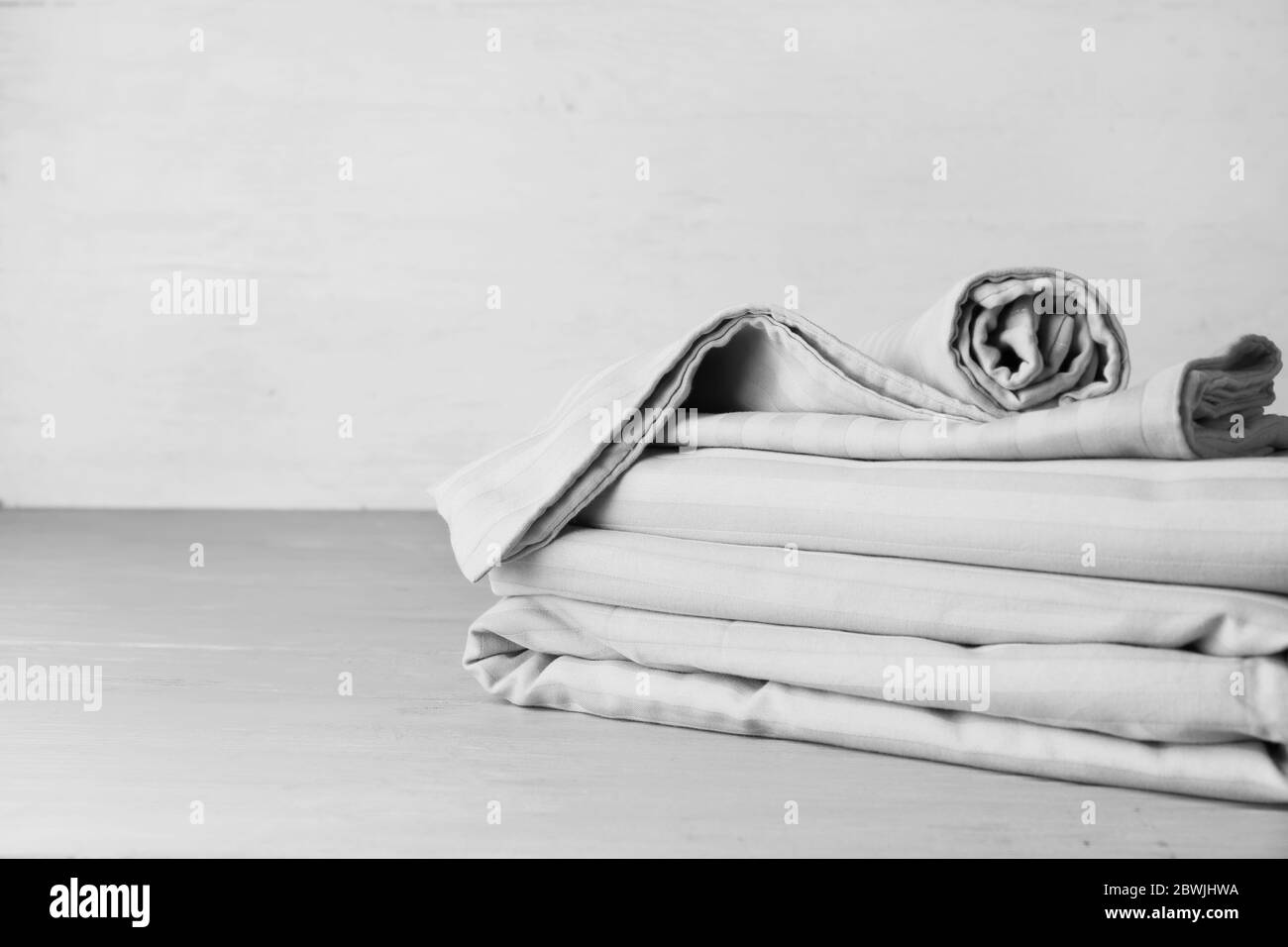Stack of clean bed sheets on table Stock Photo - Alamy