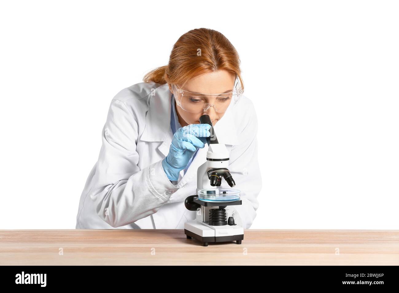 Scientist working with microscope against white background Stock Photo ...