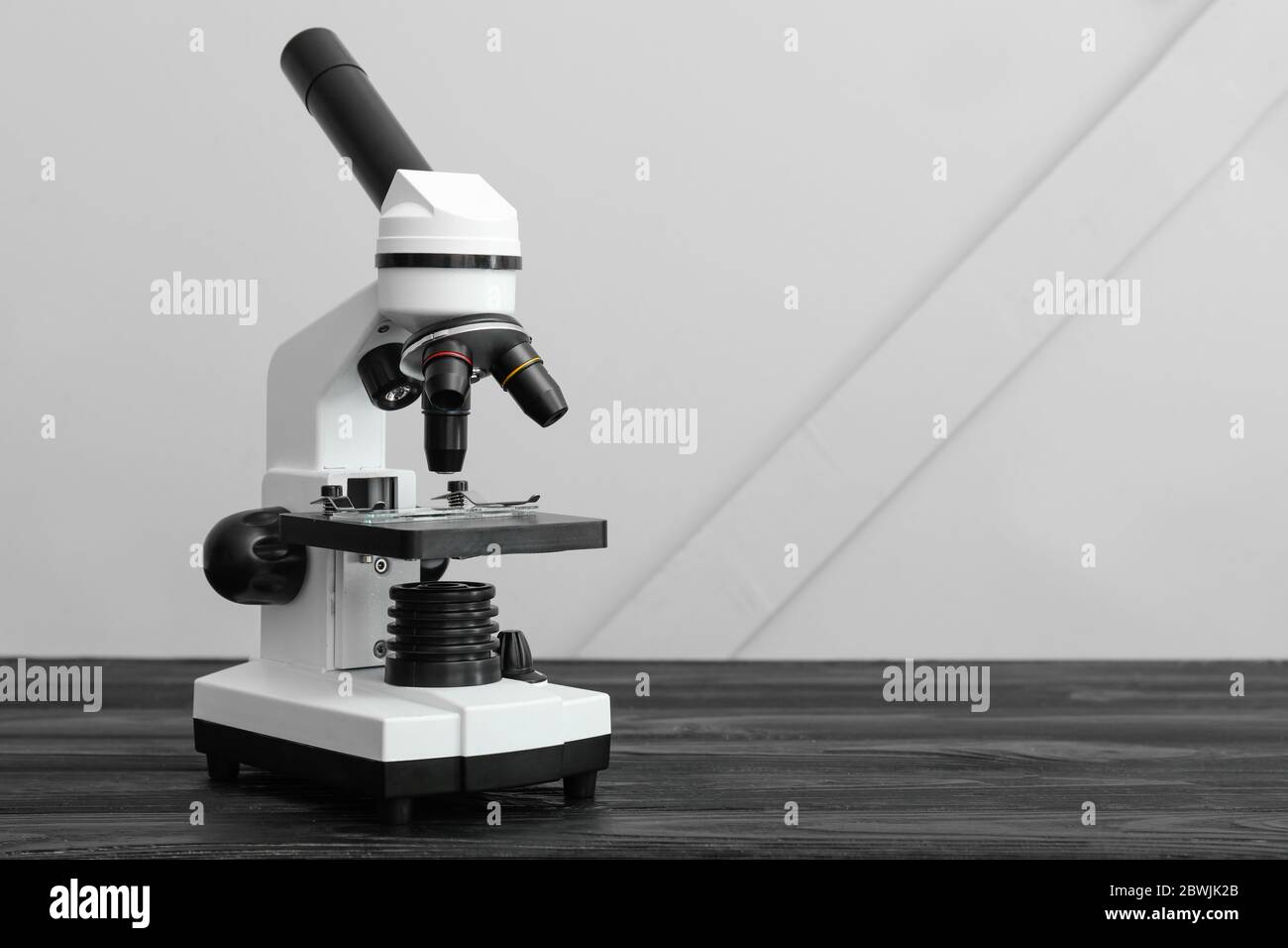 Modern microscope on table against light background Stock Photo - Alamy