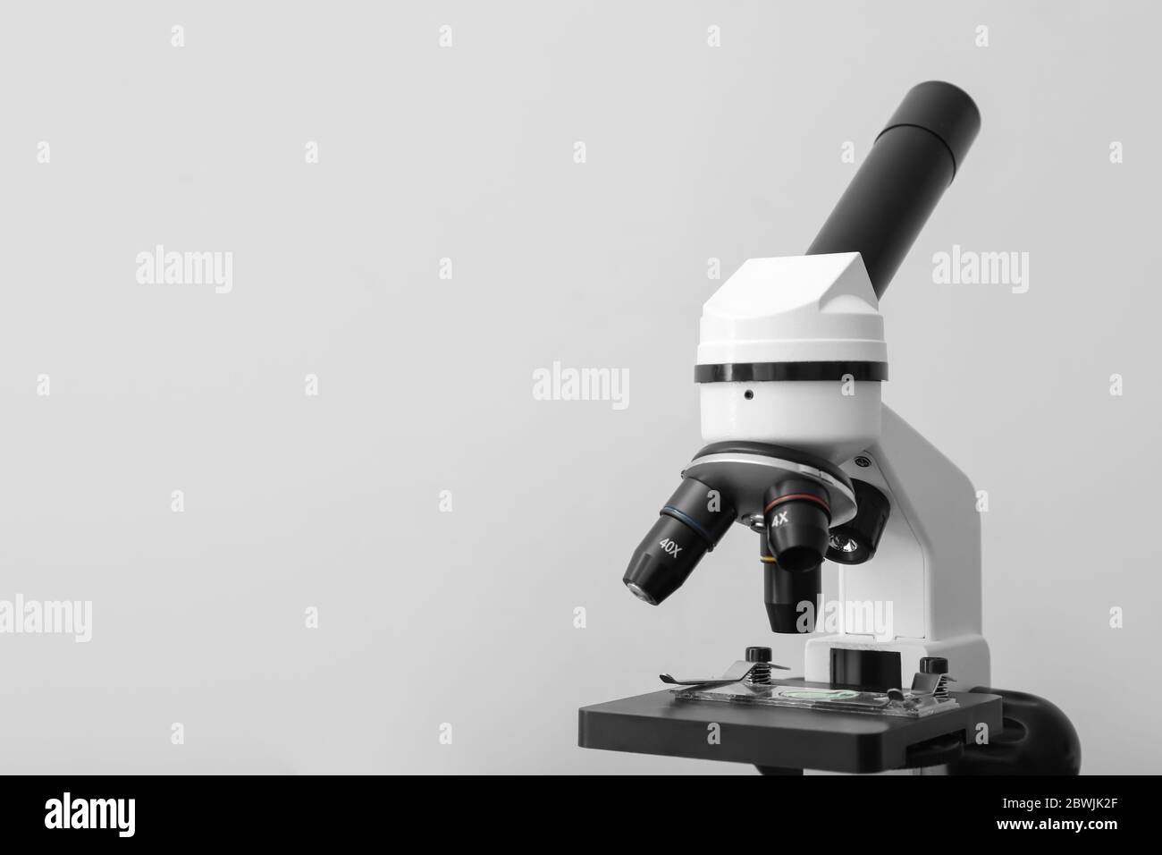 Modern microscope on light background Stock Photo - Alamy