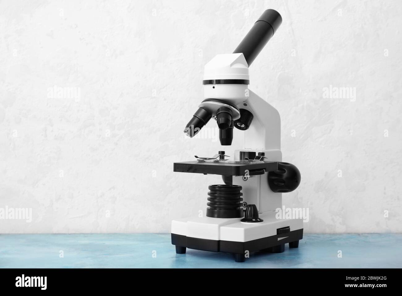 Modern microscope on table against light background Stock Photo - Alamy