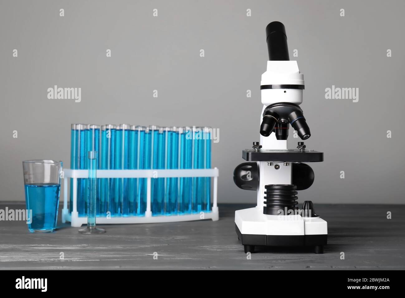 Modern microscope and test tubes on table Stock Photo - Alamy