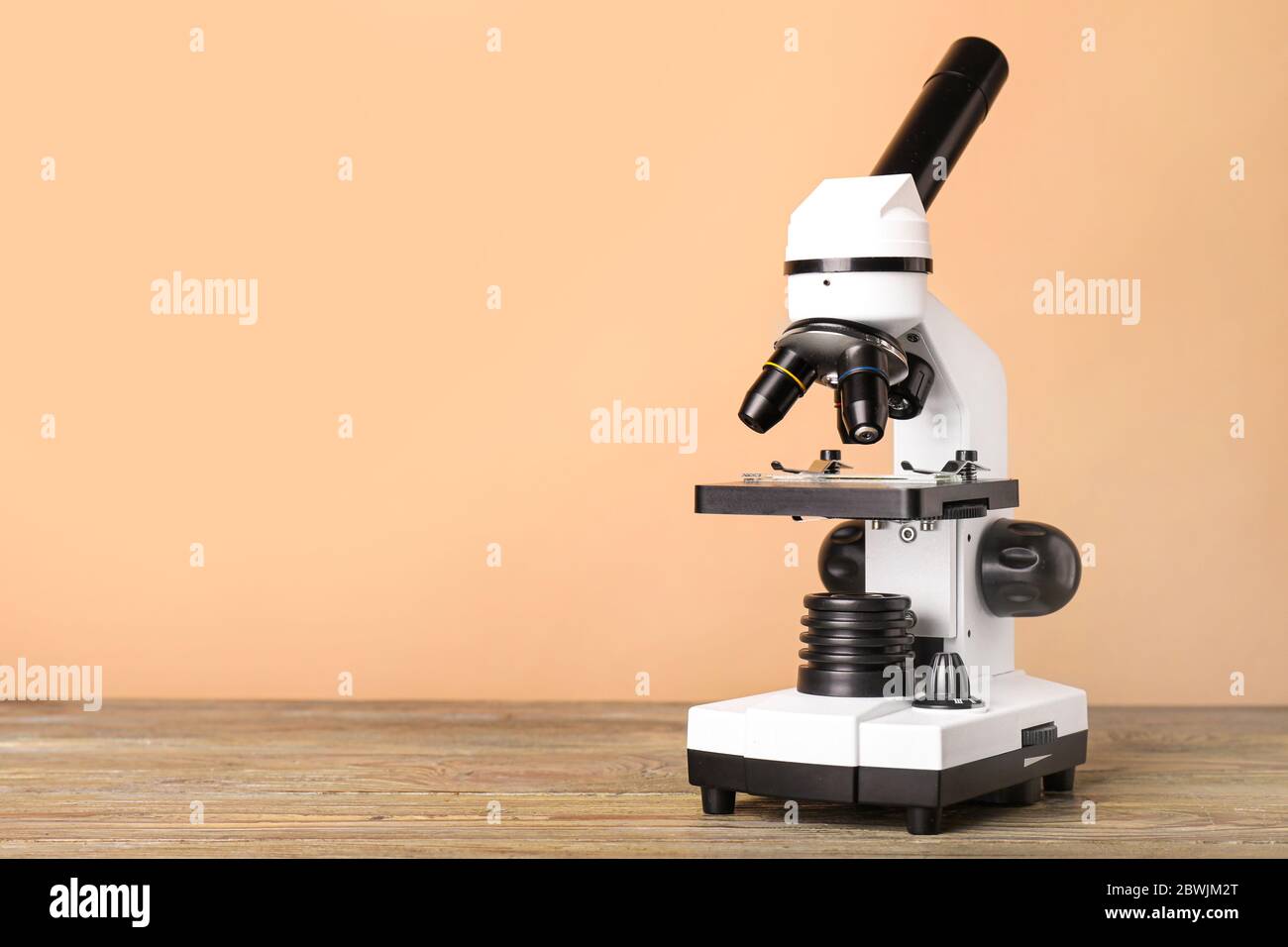 Modern microscope on table against color background Stock Photo - Alamy