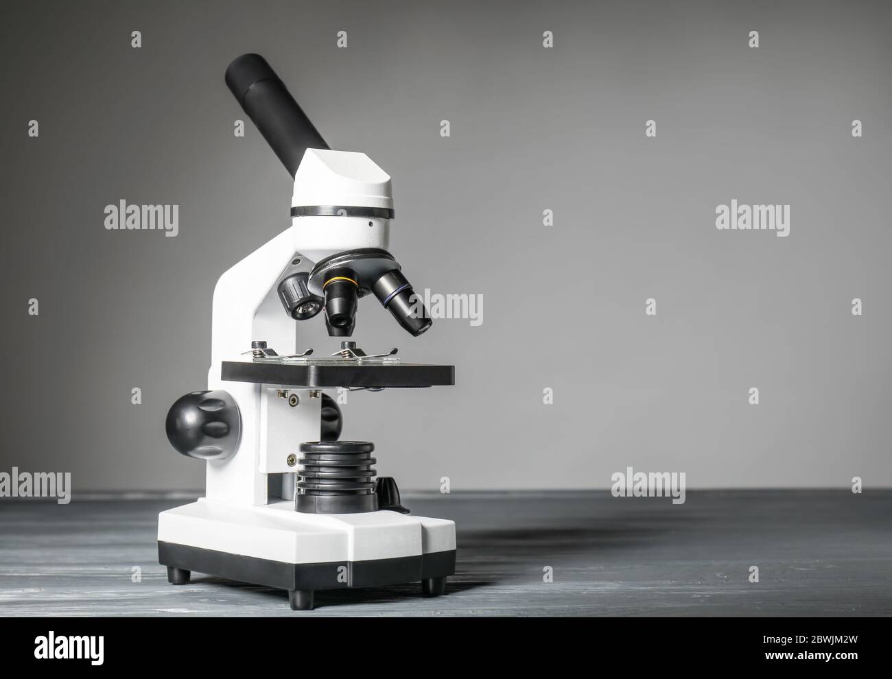 Modern microscope on table against grey background Stock Photo - Alamy