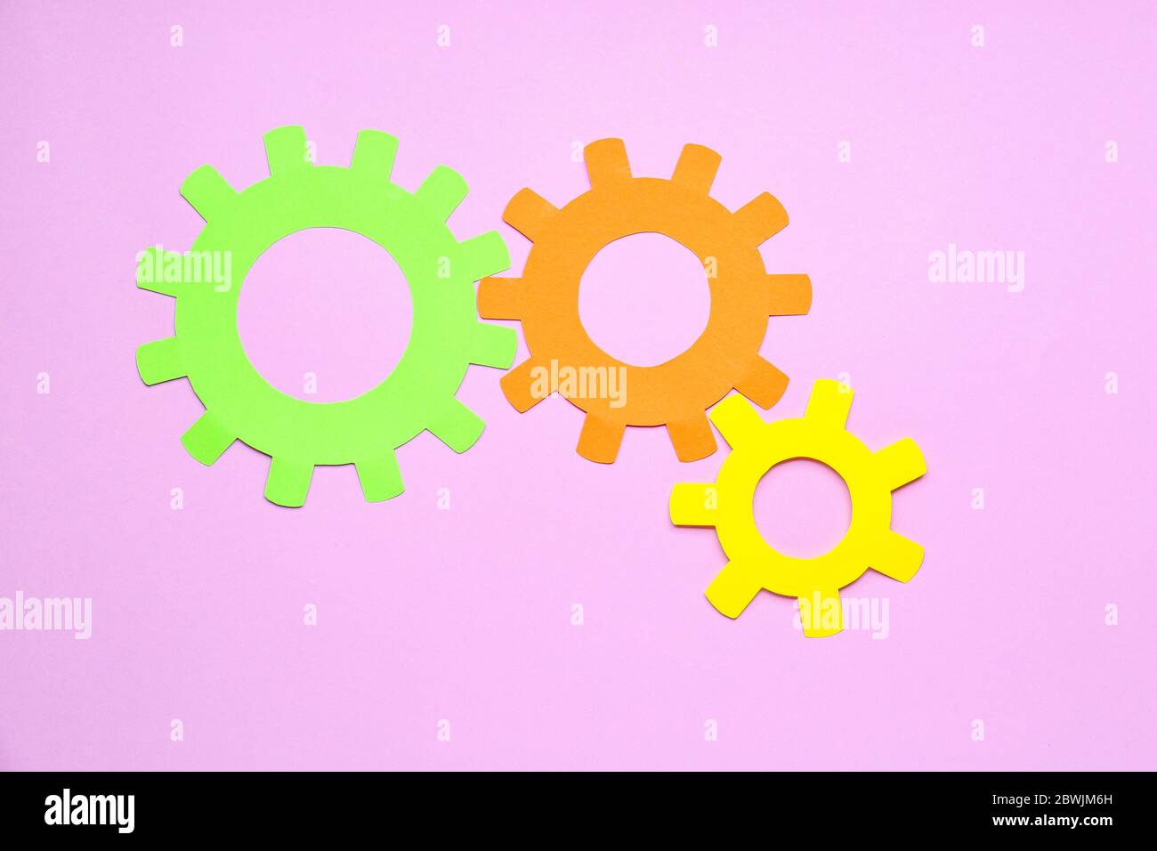 Paper gears on color background. Unity concept Stock Photo - Alamy