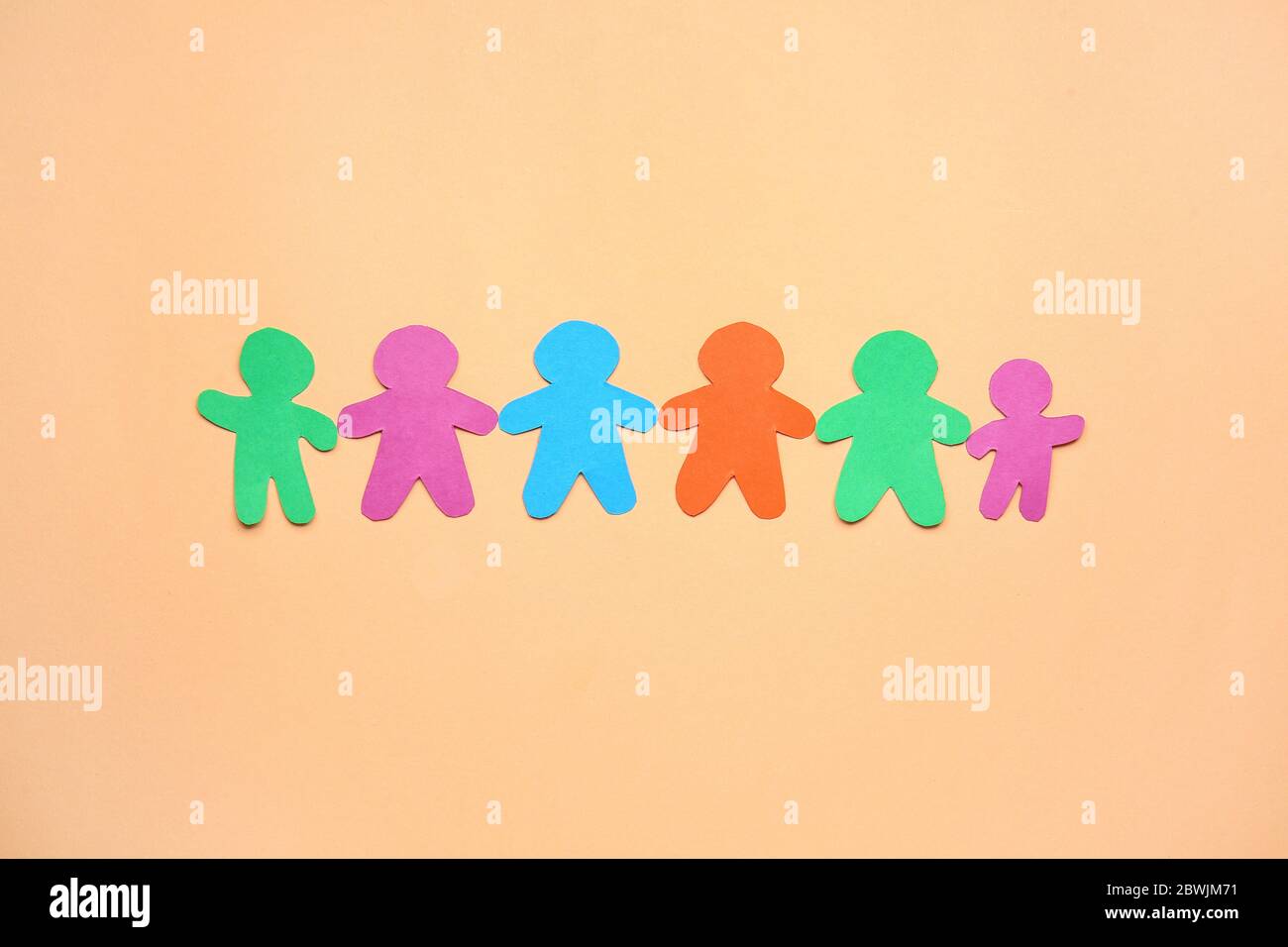 Paper human figures on color background. Unity concept Stock Photo - Alamy