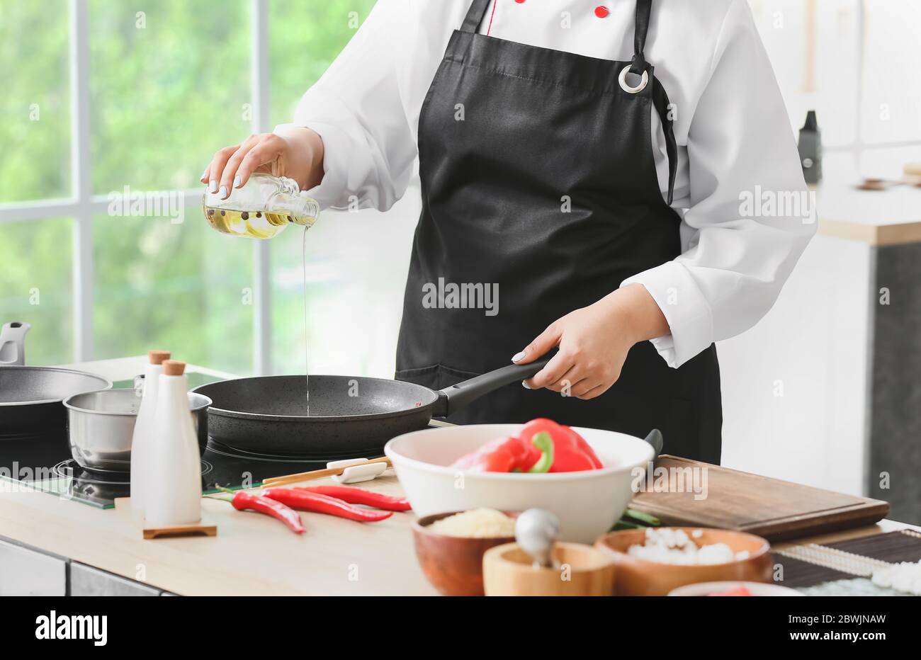 Beautiful Asian chef cooking in kitchen Stock Photo - Alamy