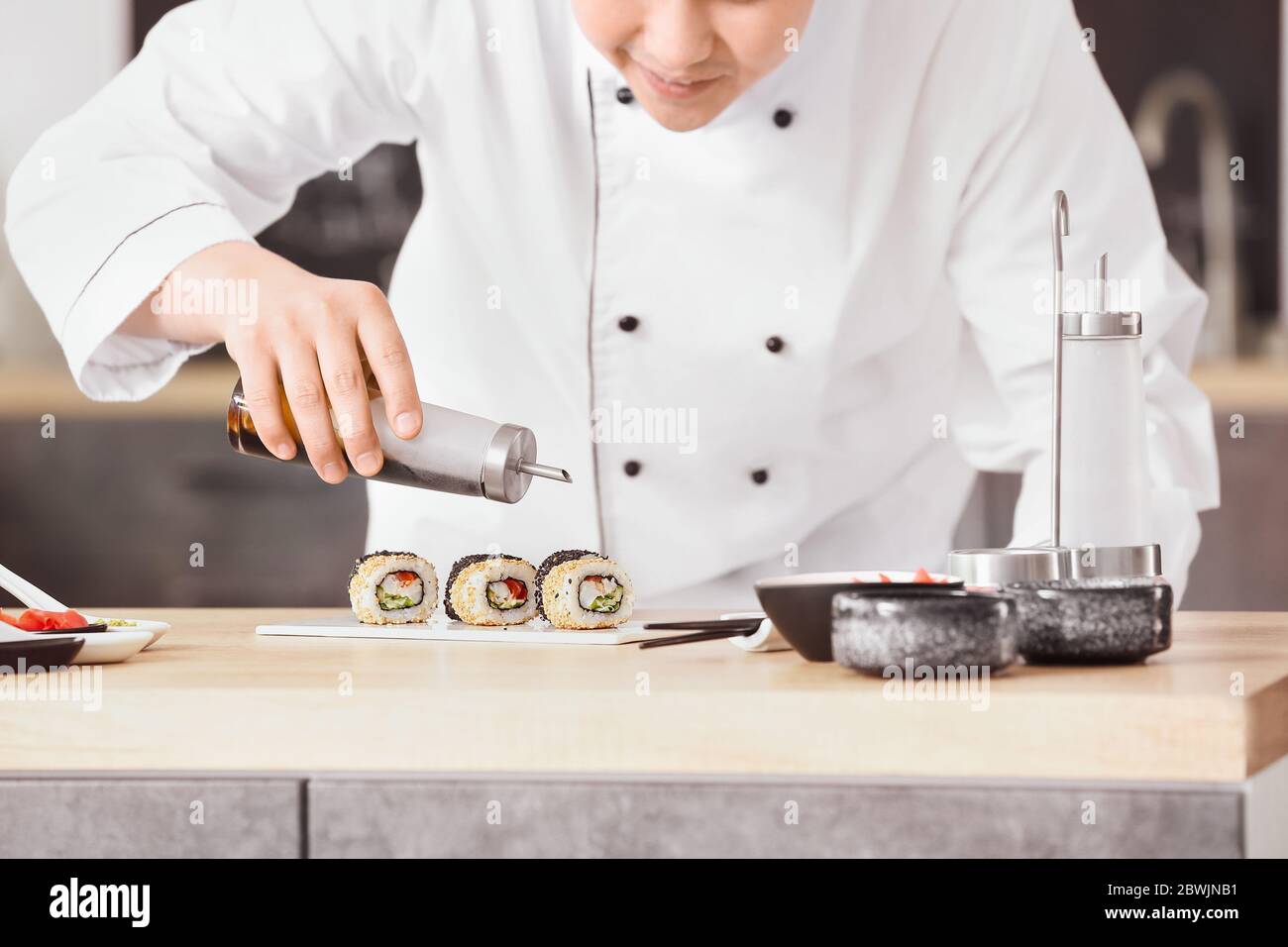 Handsome Asian chef cooking in kitchen Stock Photo - Alamy