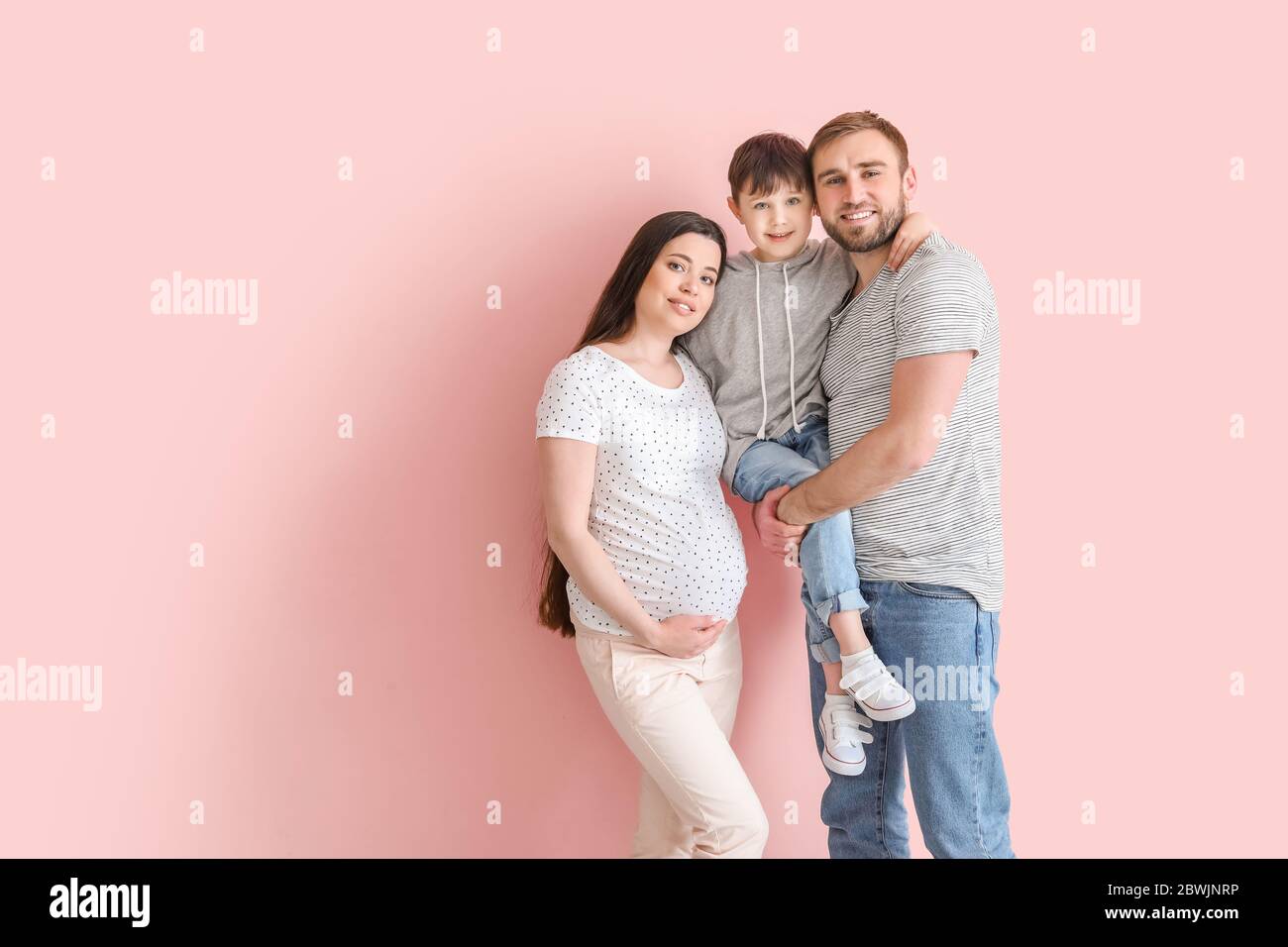 Beautiful pregnant woman with her family on color background Stock ...