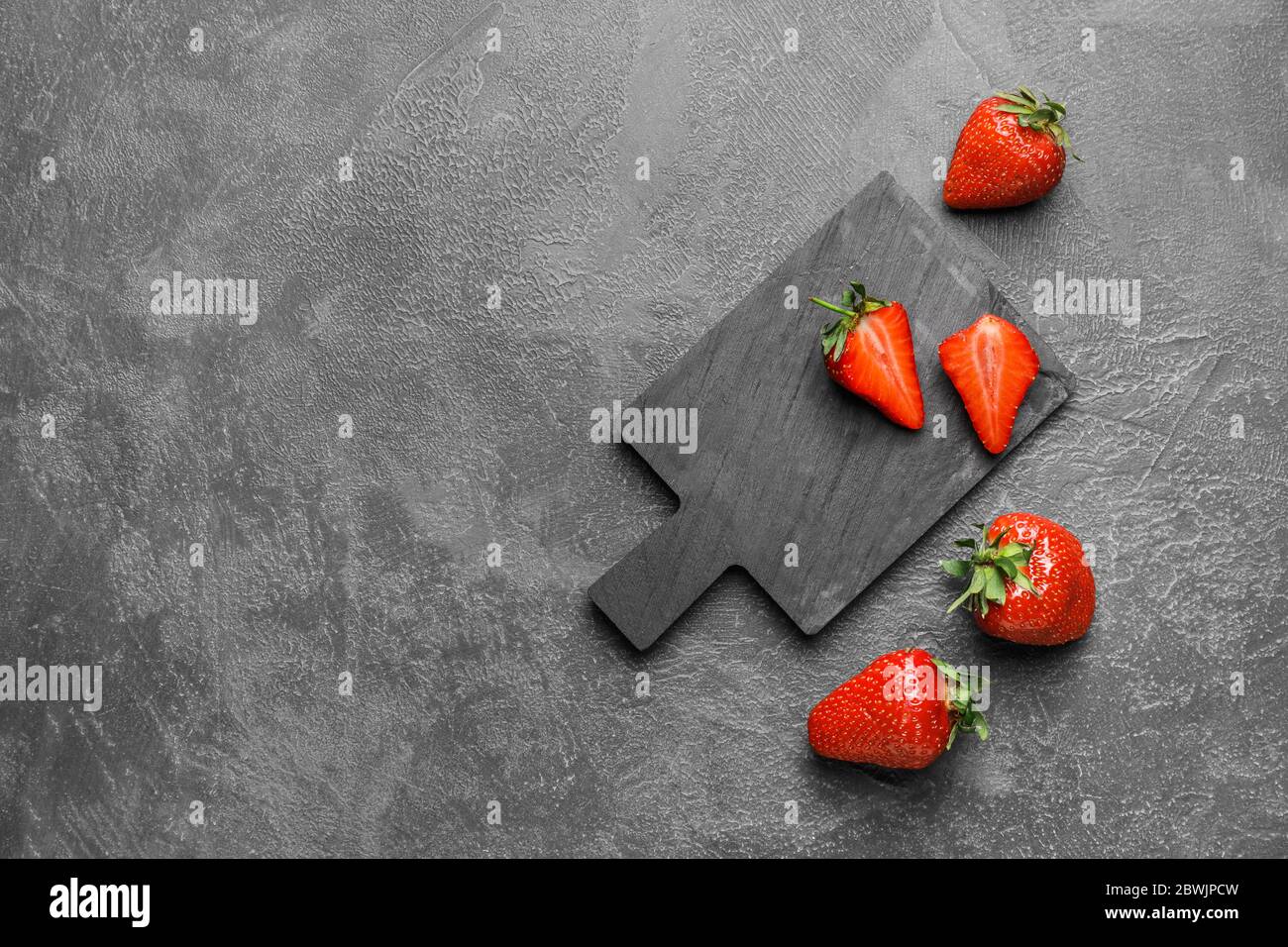 Sweet ripe strawberry on grey background Stock Photo - Alamy