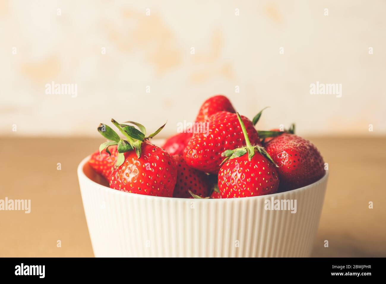 Bowl with ripe strawberry on table Stock Photo - Alamy