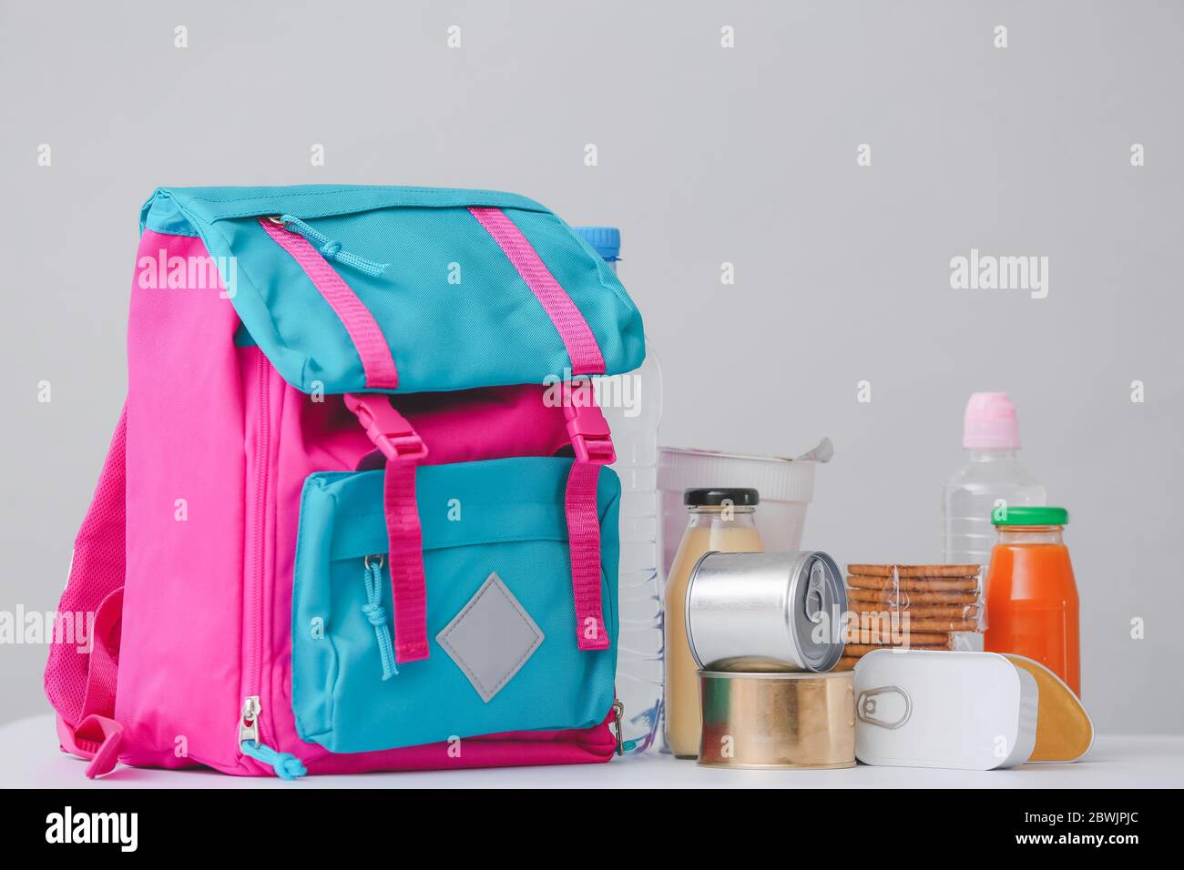 Schoolbag with different products on light background. Concept of ...