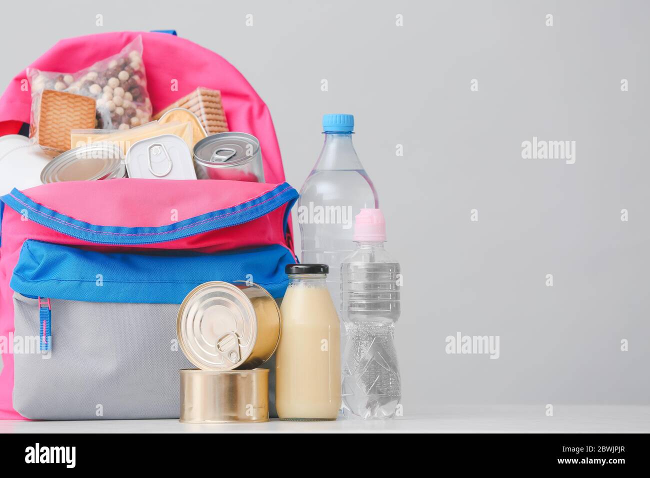 Schoolbag with different products on light background. Concept of ...