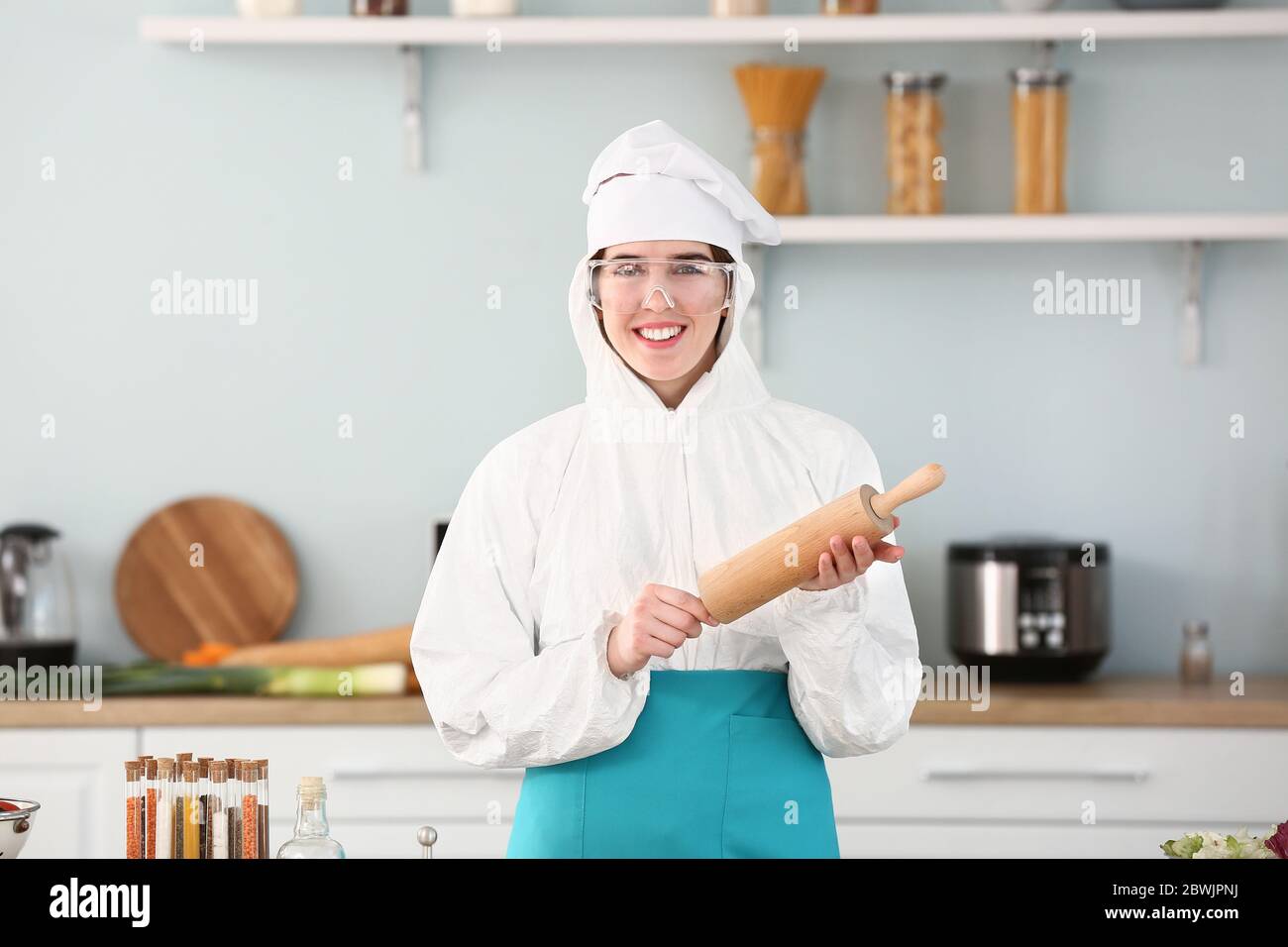 Housewife in protective costume cooking in kitchen Stock Photo - Alamy