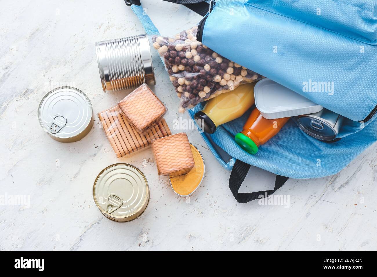 Schoolbag with different products on light background. Concept of ...