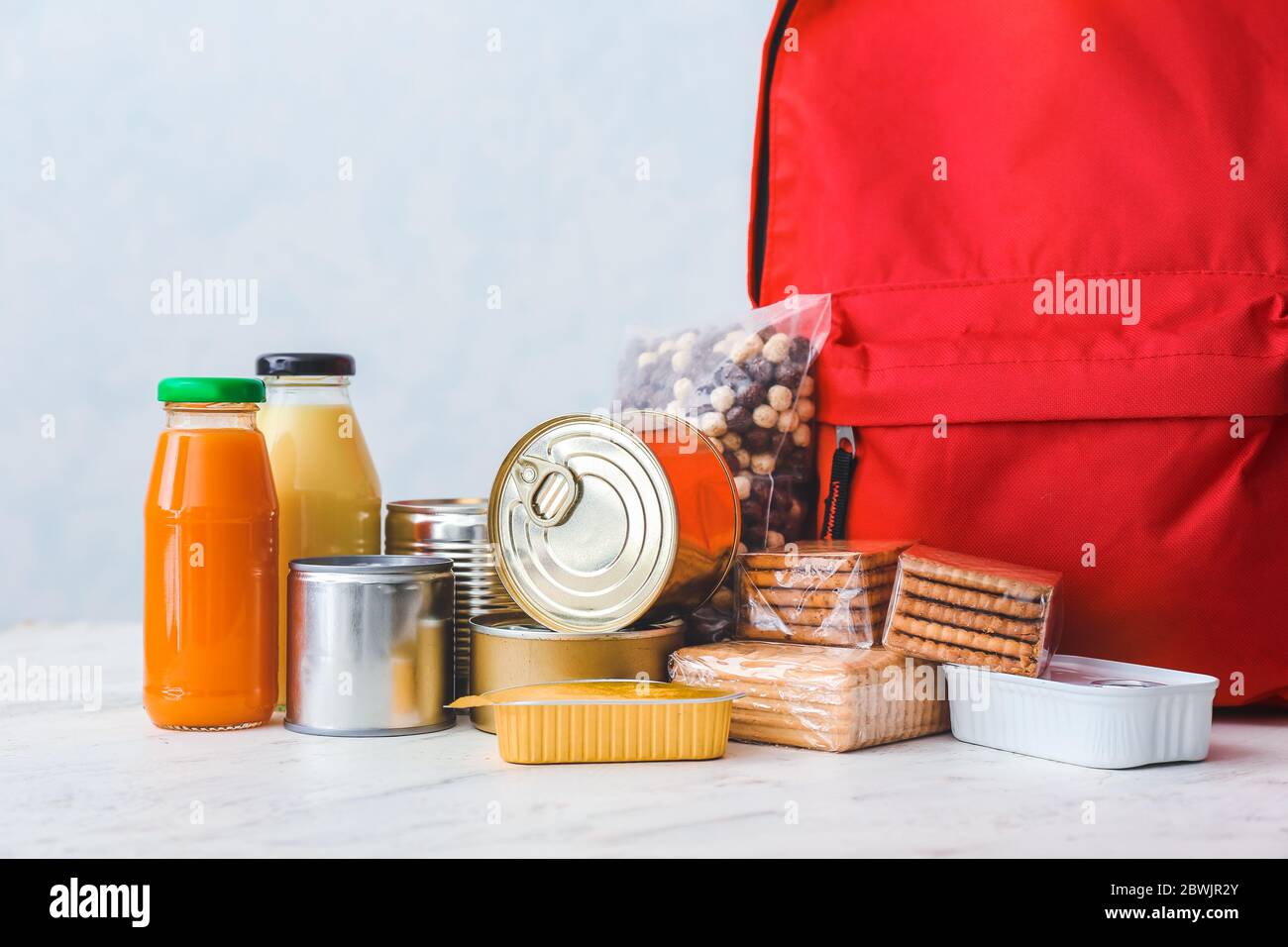 Schoolbag with different products on light background. Concept of ...