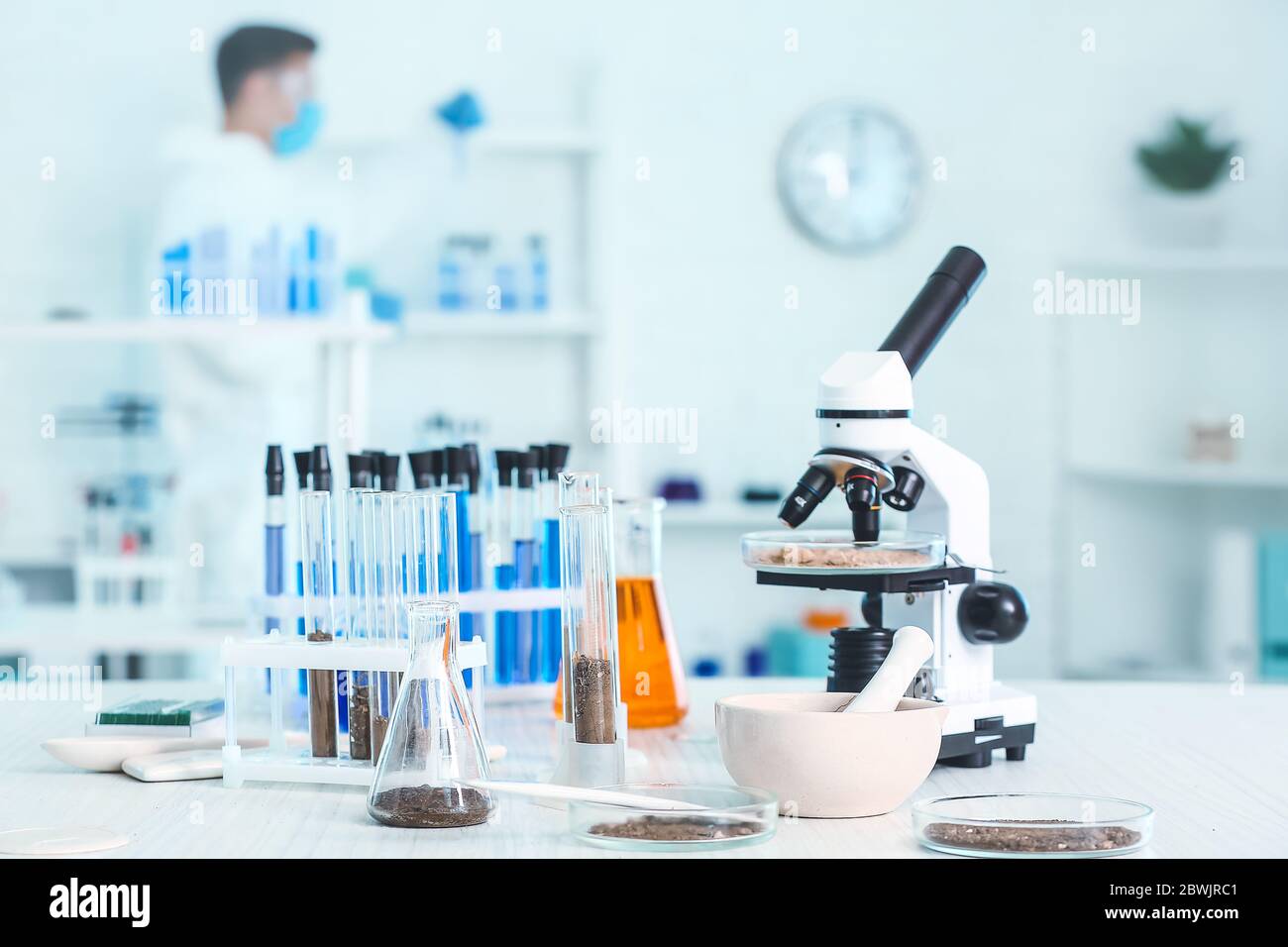 Samples of soil, microscope and glassware on table in laboratory Stock ...