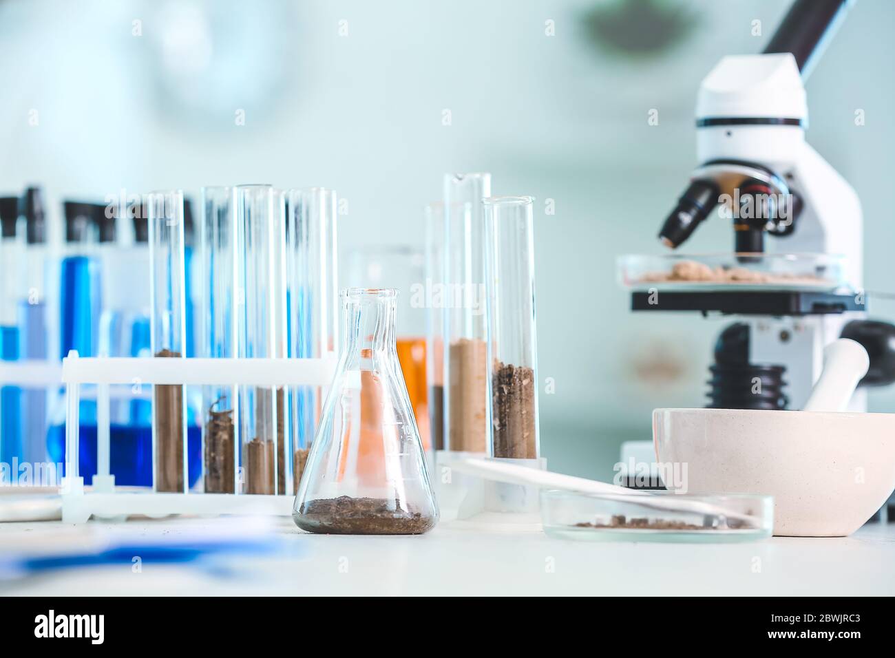 Samples of soil, microscope and glassware on table in laboratory Stock ...