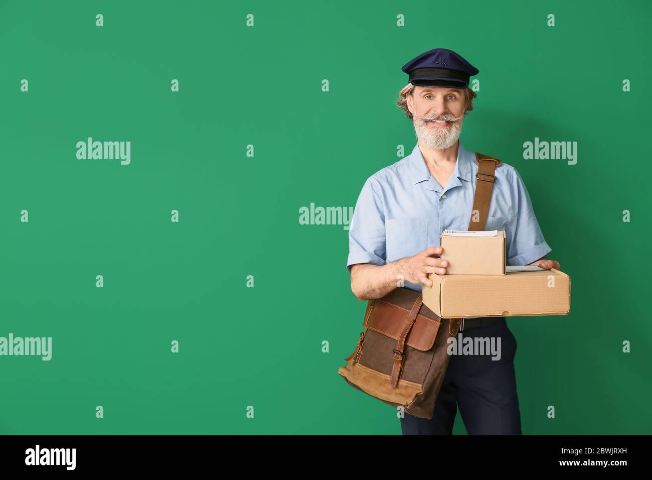Handsome old postman on color background Stock Photo - Alamy