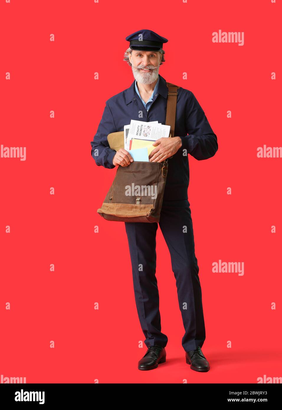 Handsome old postman on color background Stock Photo - Alamy