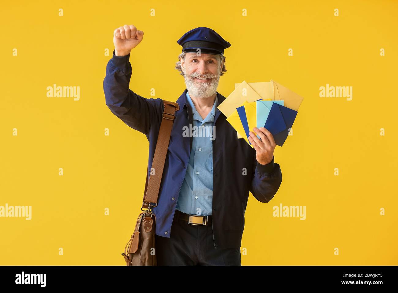 Handsome old postman on color background Stock Photo - Alamy