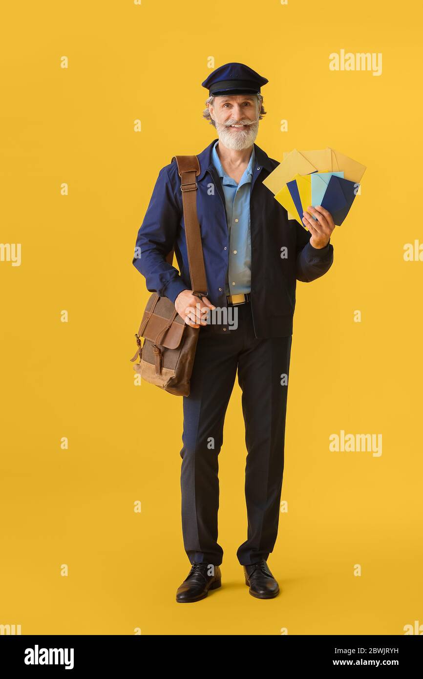 Handsome old postman on color background Stock Photo - Alamy