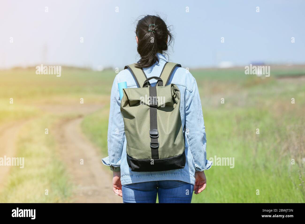 Female traveler with backpack in countryside Stock Photo - Alamy