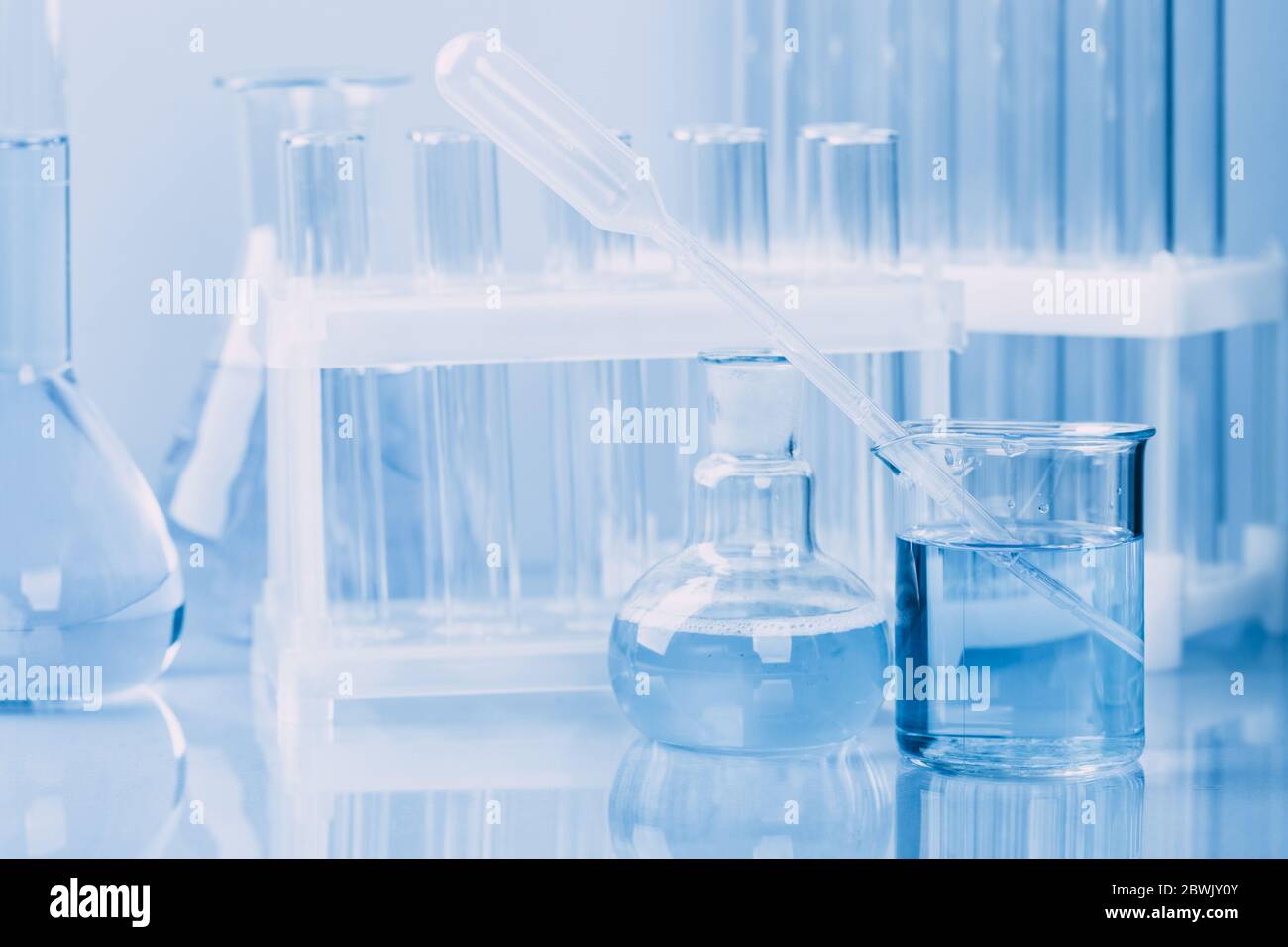 Laboratory glassware with a dropper dripping liquid into a test tube ...