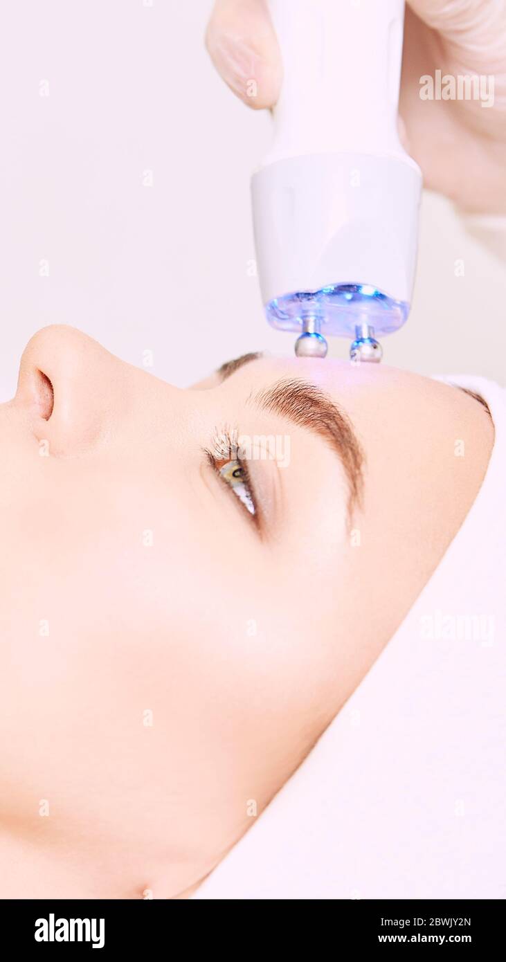 Microcurrent light esthetics procedure. Beauty girl face. Cosmetology ...