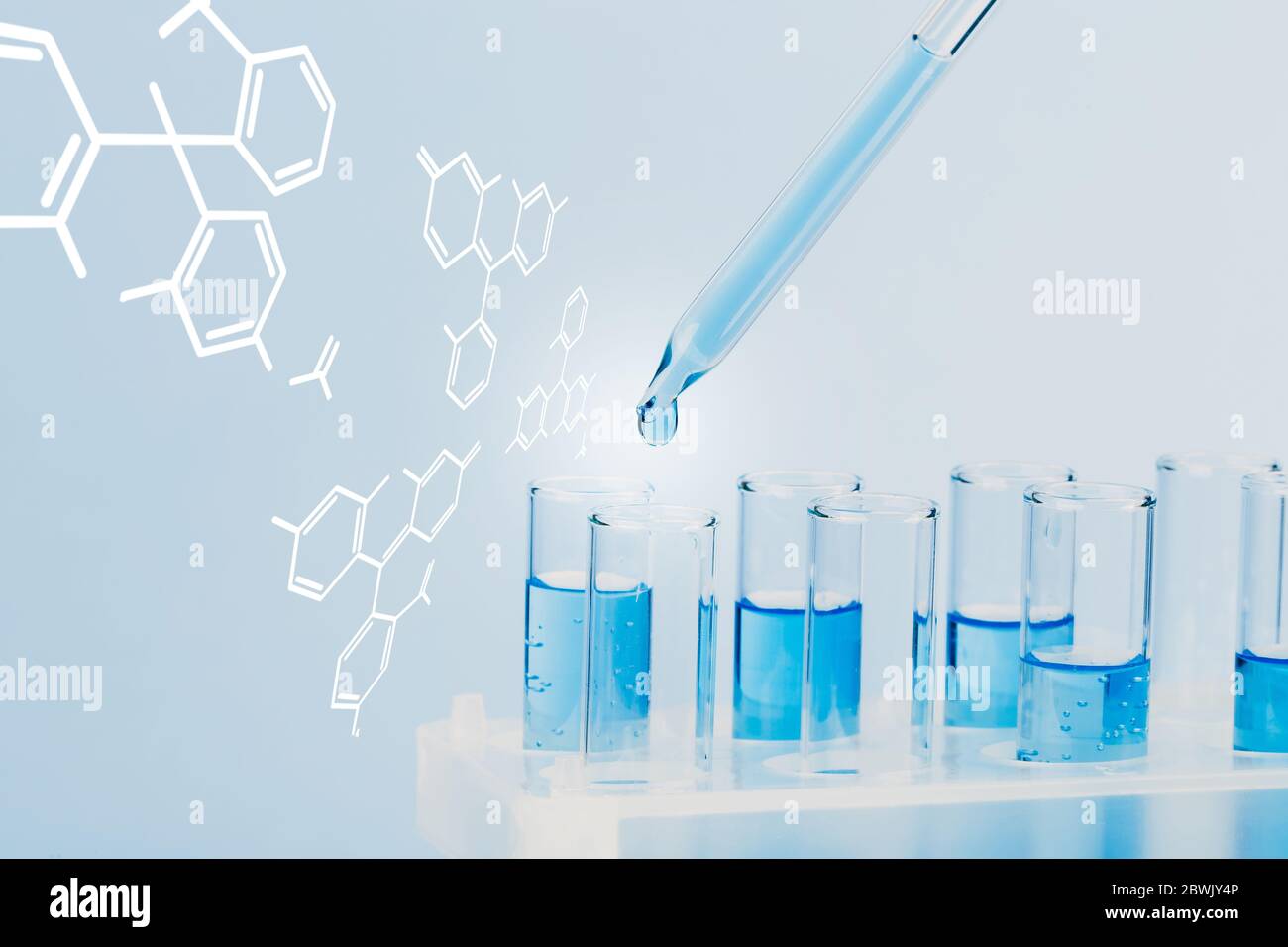 Laboratory glassware with a dropper dripping liquid into a test tube ...