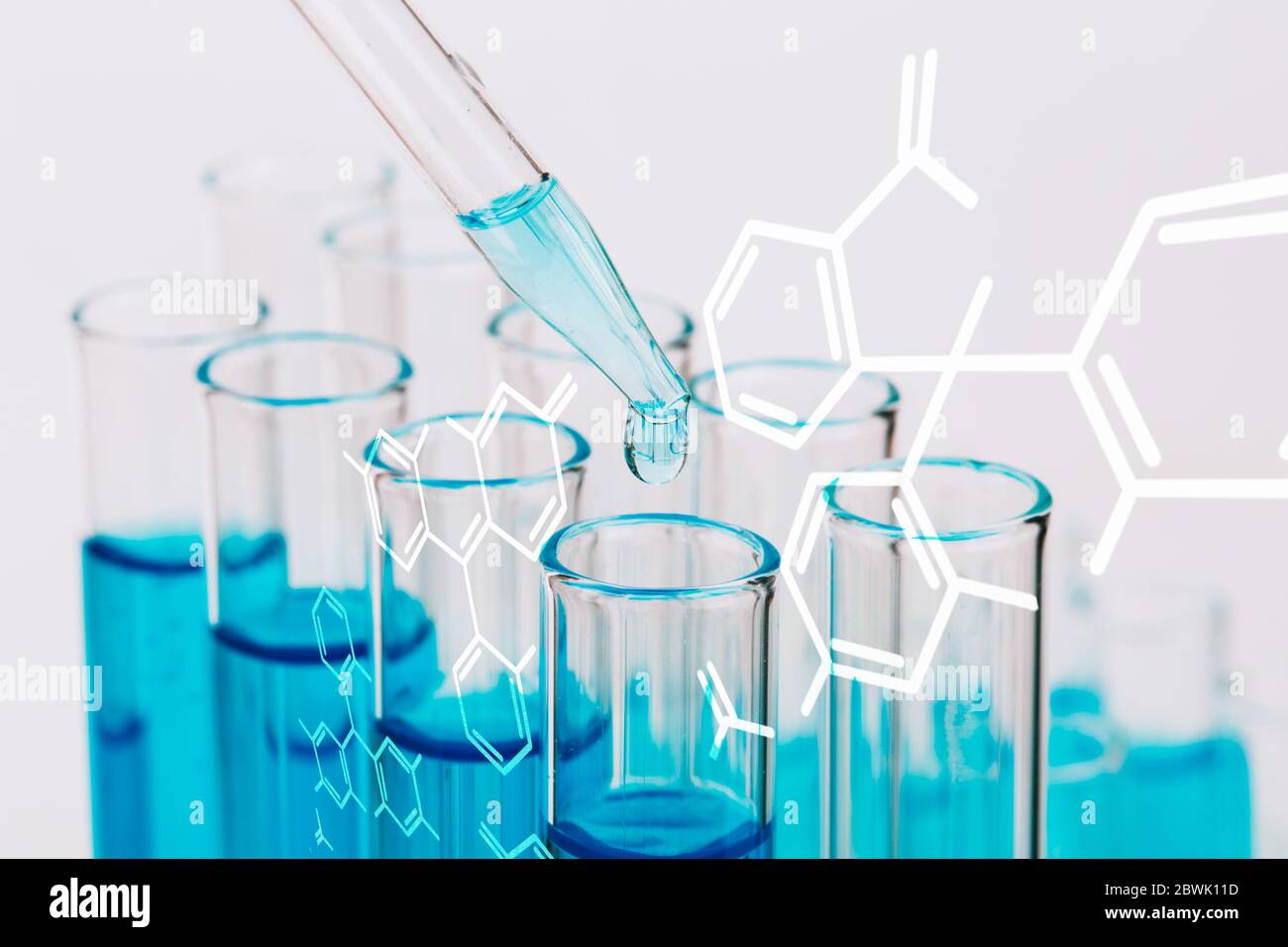 Laboratory glassware with a dropper dripping liquid into a test tube ...